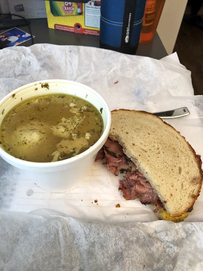 The holy trinity: matzo ball soup, a pickle spear, and what appears to be pastrami on rye. Lunchtime doesn't get more authentically deli than this.