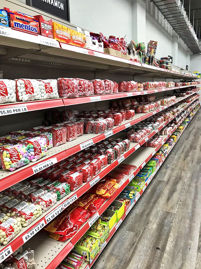 The candy aisle stretches toward infinity, where peppermints and Mentos create a red-and-white wonderland of possibilities.