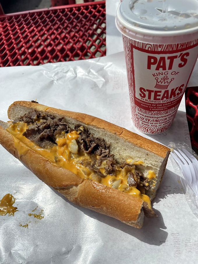 The classic Pat's cheesesteak in all its glory. That river of cheese cascading over perfectly chopped steak is what food dreams are made of.