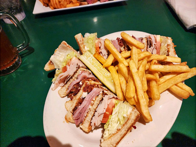 The club sandwich stands tall and proud, like the Washington Monument of lunch options, with golden fries as worthy companions.