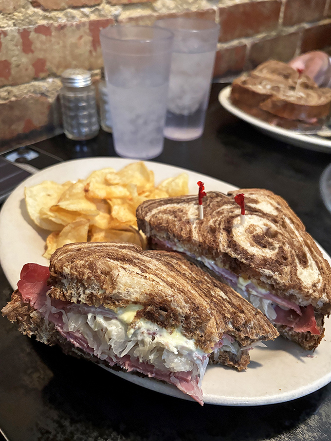 Not just a sandwich but a structural marvel: layers of corned beef and sauerkraut creating the savory skyscraper Frank Lloyd Wright never designed.