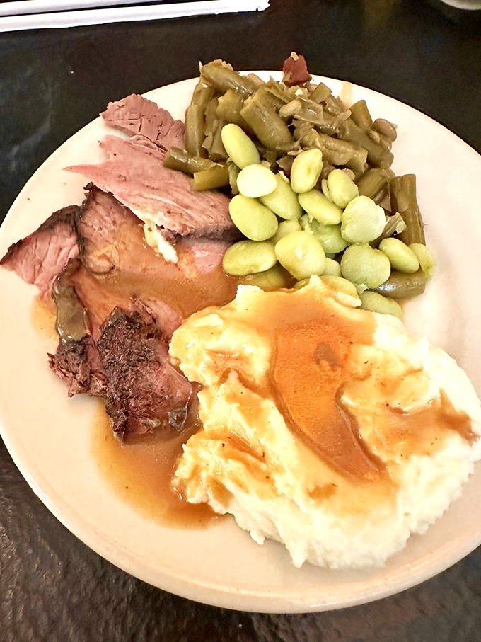 Mashed potatoes wearing gravy like a designer outfit, surrounded by roast beef and vegetables that didn't come from a freezer bag. This is edible authenticity.