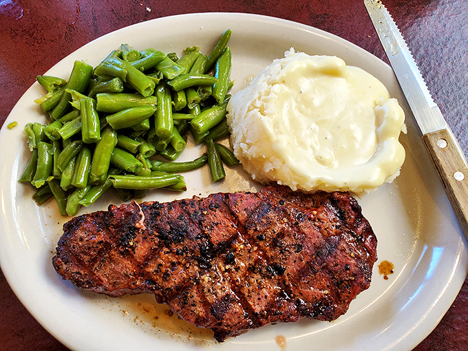 A plate that screams "Kansas": perfectly seasoned sirloin, green beans that remember what sunlight feels like, and mashed potatoes that could end arguments.