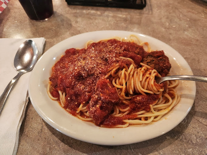 A plate that proves size matters—especially when it comes to portions. That hand comparison isn't showing off; it's providing necessary scale for this pasta monument.