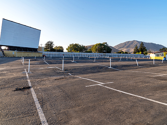 An empty lot awaiting its nightly transformation, with speaker poles standing at attention like loyal soldiers of entertainment.