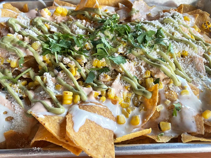 Street corn nachos that blur the line between appetizer and masterpiece. The drizzles of sauce create an edible Jackson Pollock.