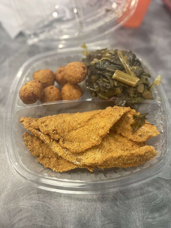 These collard greens have clearly been simmering since dawn, sharing secrets with the perfectly cornmeal-crusted whiting on the side.