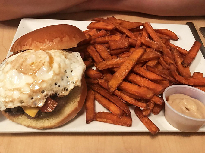 Breakfast meets burger in this morning masterpiece. The sunny-side-up egg perches atop the patty like it's claiming new territory for breakfast nation.