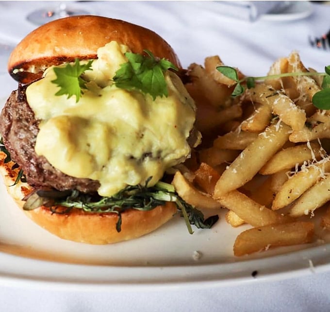 This isn't just a burger&mdash;it's architecture. The golden crown of what appears to be b&eacute;arnaise sauce transforms an everyday sandwich into weekend-worthy indulgence.