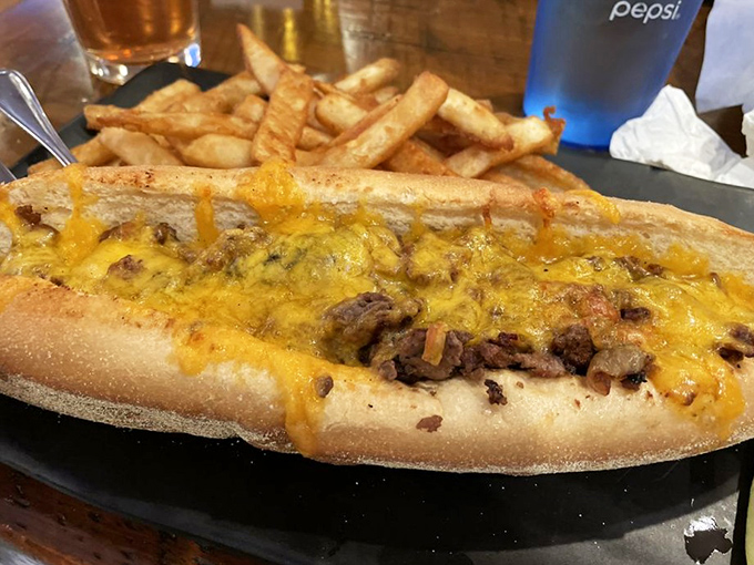 The cheesesteak that ate Philadelphia, this golden-crowned beauty lounges on its plate like royalty, surrounded by a court of french fries.