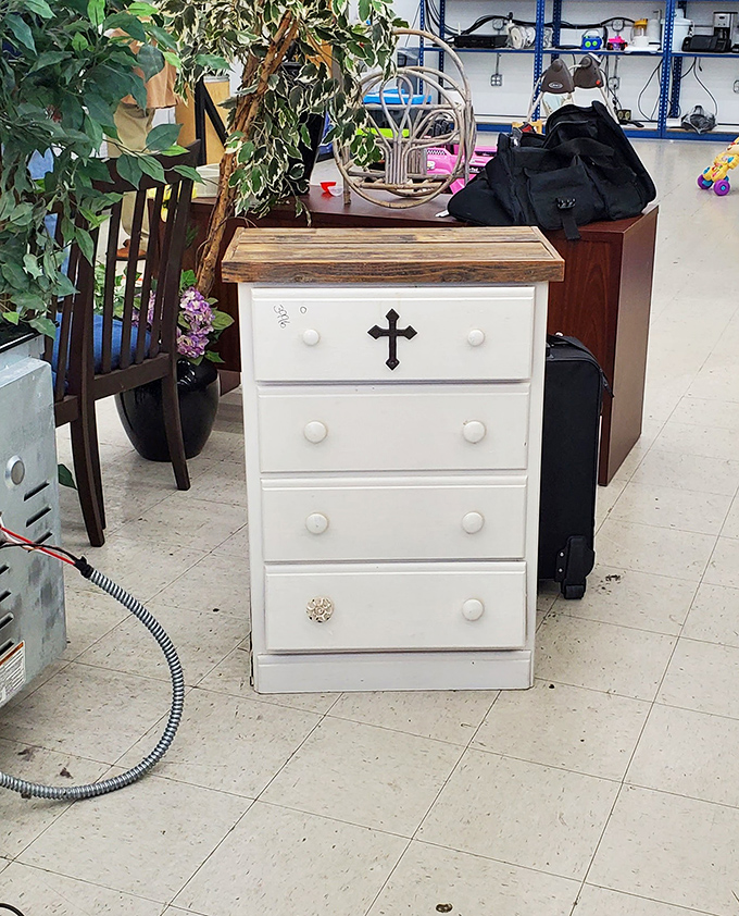 This white dresser with its cross detail and mismatched knob tells a story of reinvention&mdash;the thrift store philosophy in furniture form.