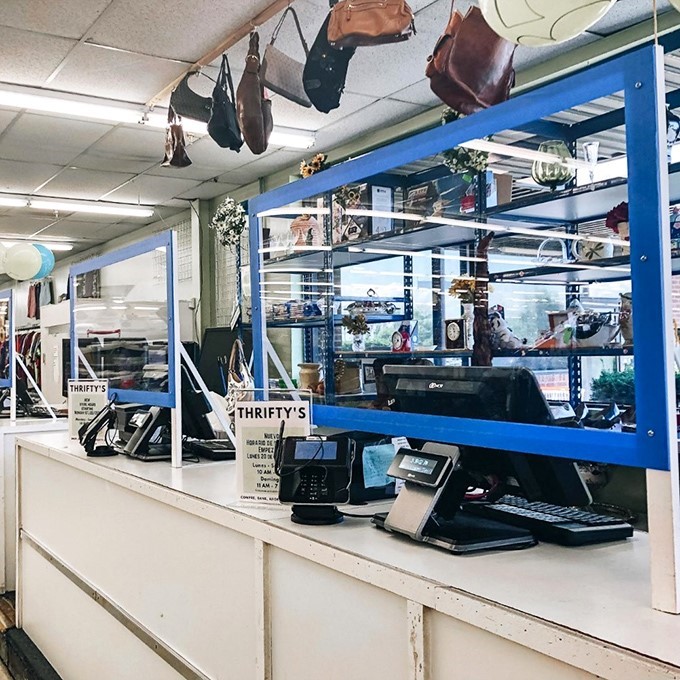 Command central: where treasures are tallied and transactions completed under the watchful eye of "THRIFTY'S" signage and a collection of vintage handbags.