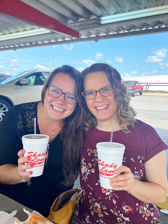 The universal language of drive-in satisfaction, captured perfectly with those iconic cups and genuine smiles.