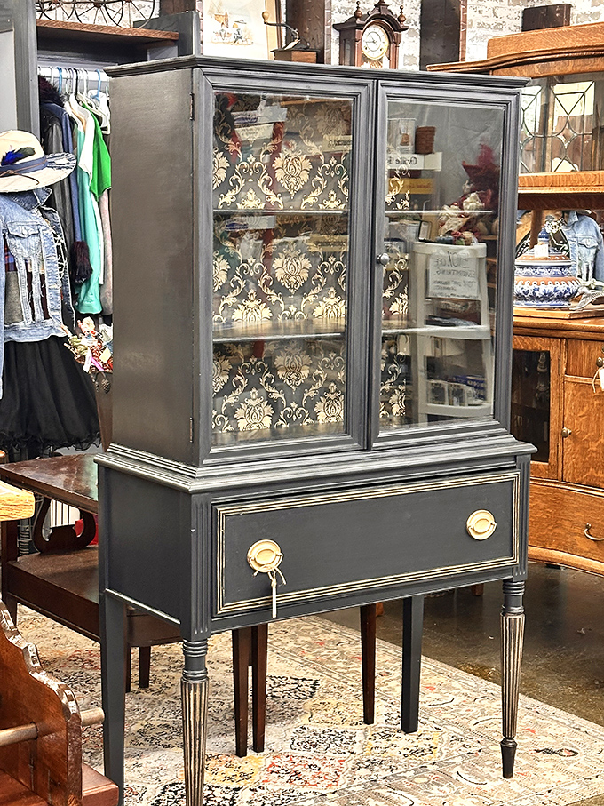 This refined display cabinet with damask backing isn't just furniture&mdash;it's architecture for your treasures, giving ordinary objects the gallery treatment they deserve.