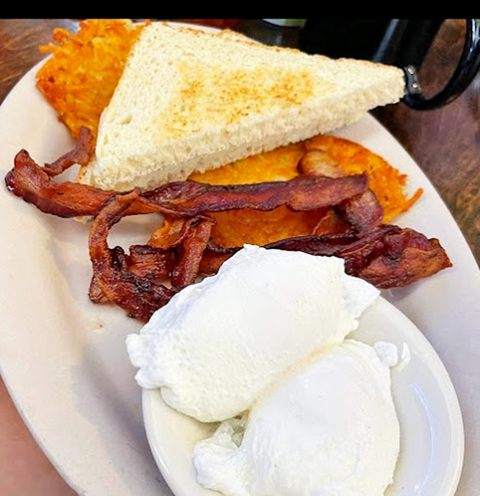 Two poached eggs standing at attention next to bacon that's achieved that magical state between chewy and crisp &ndash; breakfast perfection exists!