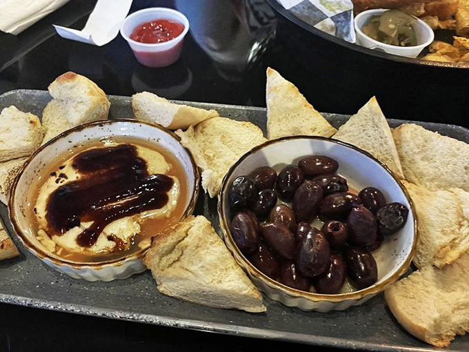 Hummus and olives presented with the simplicity of Mediterranean wisdom&mdash;proof that sometimes the most straightforward dishes speak the most eloquent culinary language.