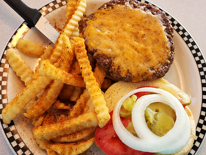 The cheeseburger arrives like a headliner with its entourage of golden fries, crisp pickles, and fresh veggies. Rock stars of the food world.