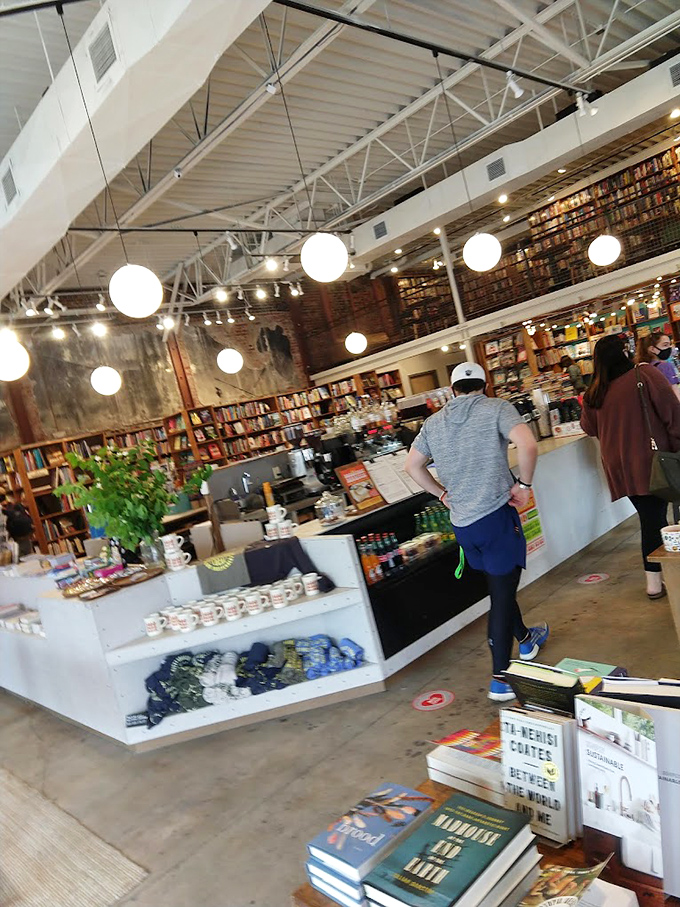 Industrial meets intellectual at the spacious checkout counter, where globe lights hover like planets in an orderly universe of words and coffee.