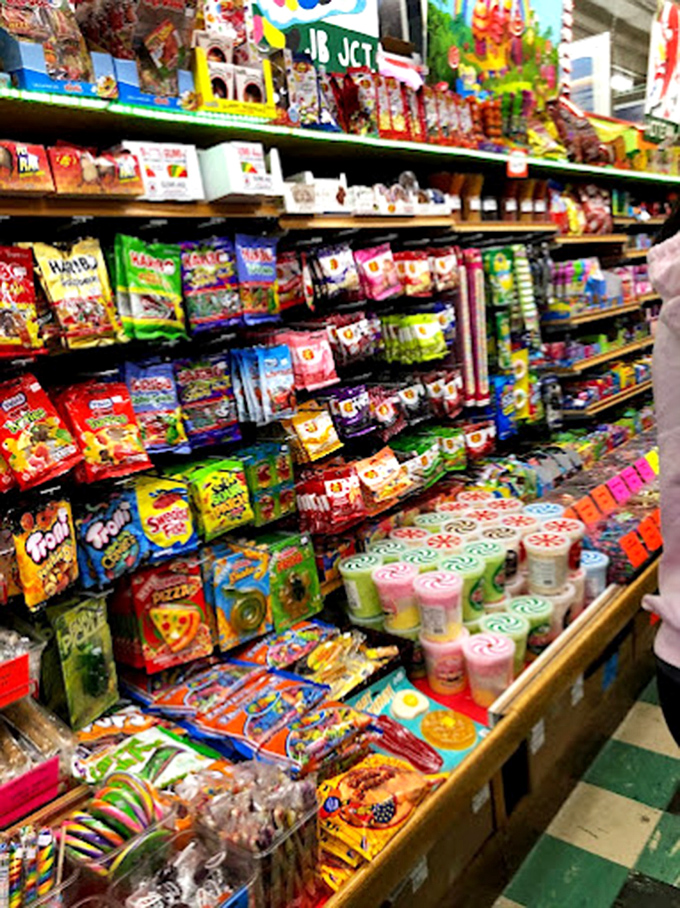 The Candy Emporium sign hangs like a sweet North Star, guiding sugar-seekers to their destination. Even adults become wide-eyed kids beneath it.