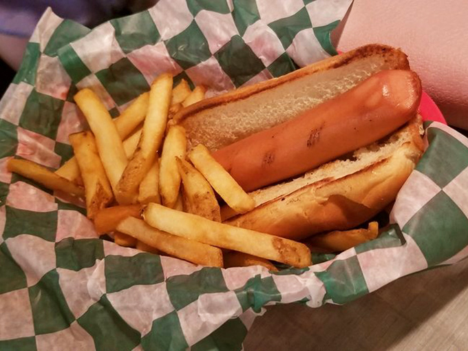 The classic American childhood on a checkered paper&mdash;a perfectly grilled hot dog nestled in a soft bun with golden fries standing at attention alongside.