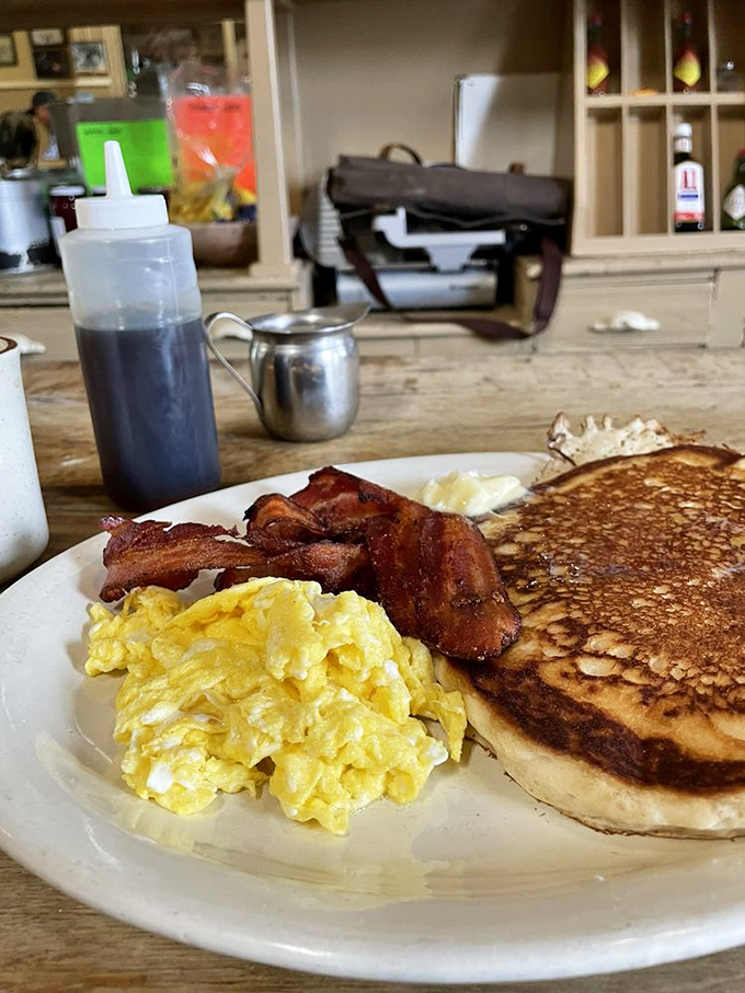 The holy trinity of breakfast perfection: golden pancakes, fluffy scrambled eggs, and bacon cooked to that magical point between chewy and crisp.