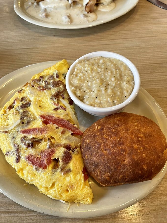 This omelet, grits, and biscuit trio forms the holy trinity of breakfast perfection&mdash;a plate that says "Good morning" in the most sincere way possible.