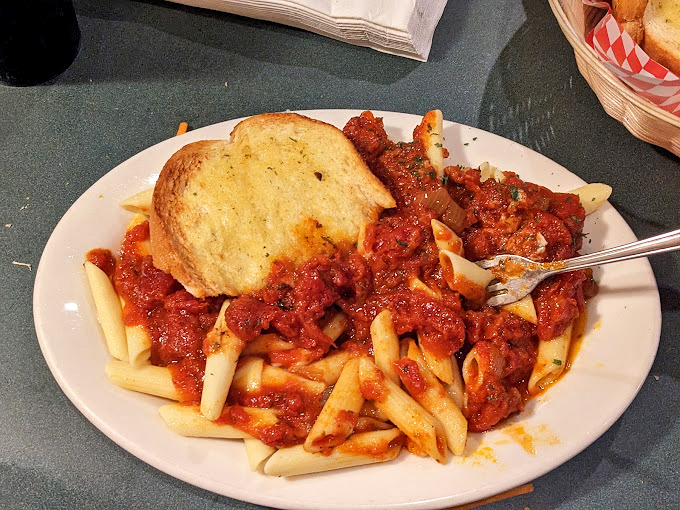 Penne pasta topped with garlic bread that's clearly not playing by the carb-counting rules. This is rebellion on a plate, and I'm here for it.
