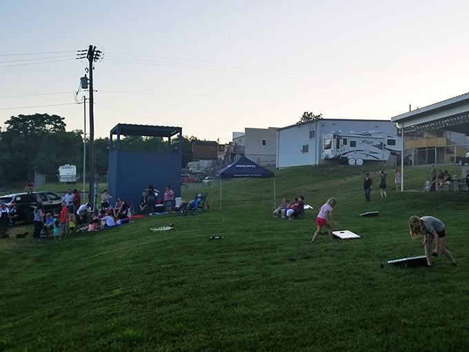 The grassy hill becomes an impromptu picnic ground before showtime, where kids burn energy and adults stake out prime viewing spots. Photo credit: pezdisc