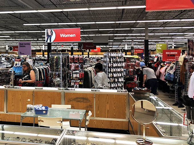 The women's clothing section buzzes with activity as shoppers hunt for hidden gems among racks organized by size and color.