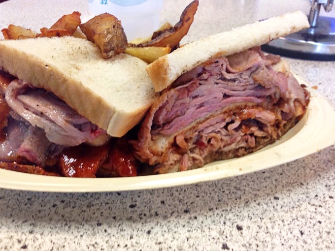 This sandwich defies architectural logic&mdash;impossibly stacked meat on humble white bread somehow holding together just long enough to make it to your mouth.