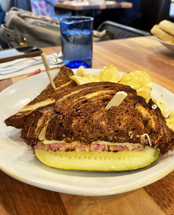 This isn't just a sandwich; it's architecture with purpose. Perfectly toasted rye cradles what appears to be a masterclass in proper meat-to-pickle ratio, with chips standing guard.