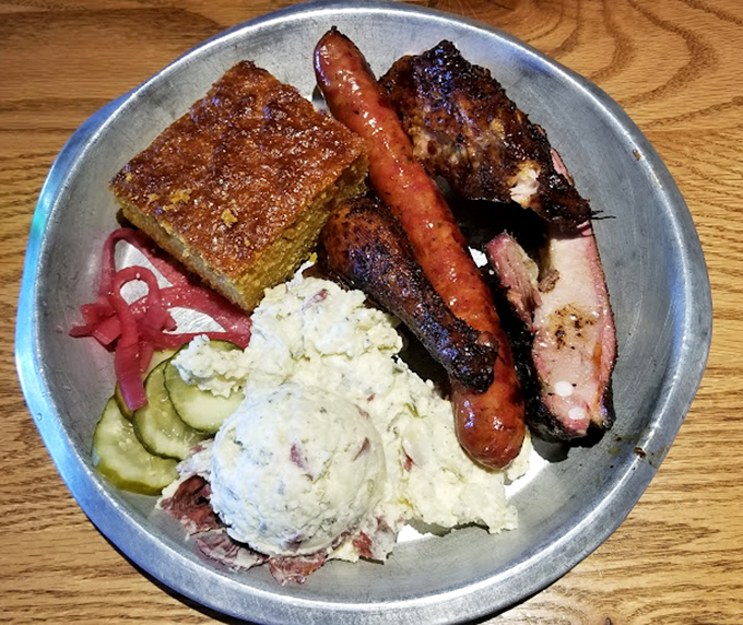A metal tray loaded with smoky treasures and sides that complement rather than compete. That cornbread deserves its own fan club.