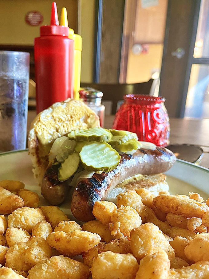 The bratwurst that launched a thousand tailgates, nestled in a proper bun with those legendary cheese curds. 