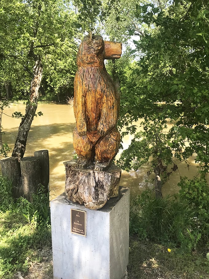 This wooden bear sculpture stands sentinel by the river, carved with the kind of rustic charm that makes you wonder if it comes alive after visitors leave.