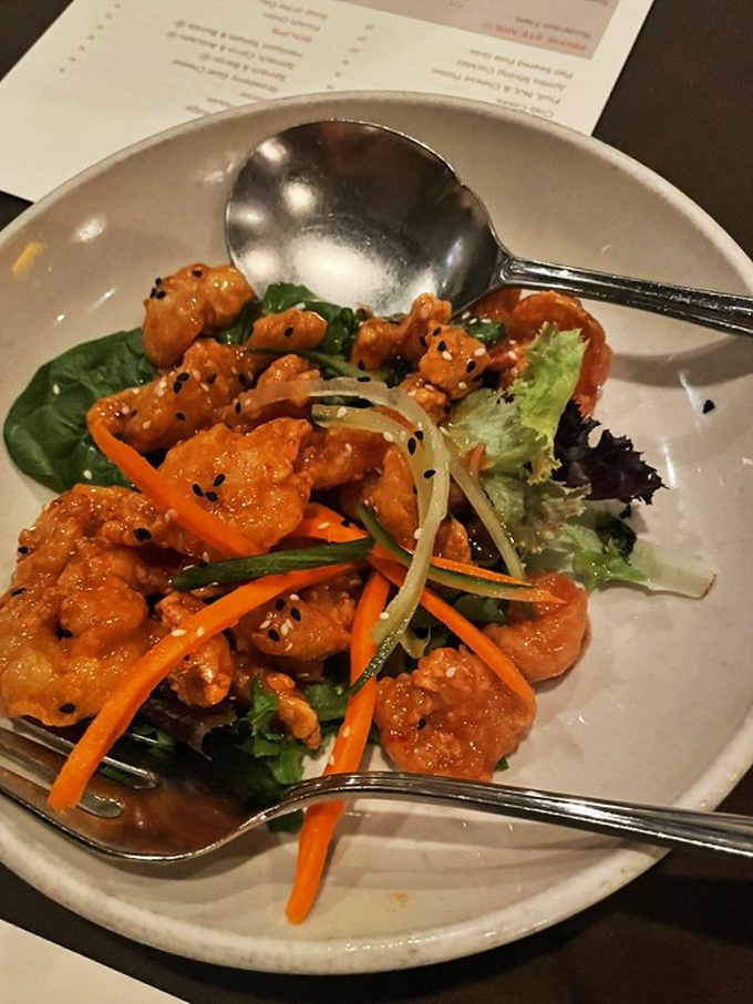 Glazed shrimp perch atop fresh greens like jewels, offering a lighter option that sacrifices nothing in the flavor department.