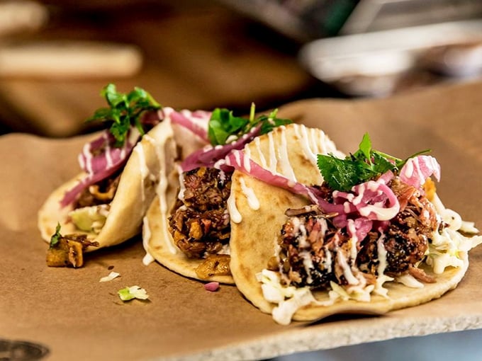 Tacos reimagined through the smoke-tinted lens of BBQ mastery, where tender meat meets fresh toppings in a handheld flavor explosion.