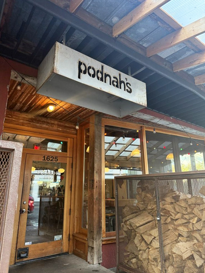 Podnah's Pit - Firewood stacked like treasure outside the door. In BBQ math, wood plus time equals deliciousness.