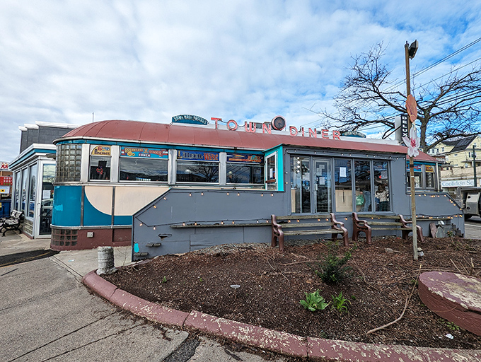 The Deluxe Town Diner's curved turquoise roof swoops like the perfect wave of breakfast nostalgia crashing over Watertown.