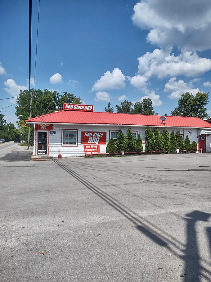 Under Kentucky's blue skies, Red State's red roof signals BBQ bliss ahead. The evergreen shrubs outside are probably there to hide the drooling customers!
