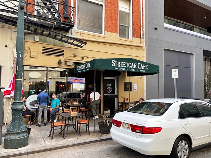 Green tables invite sidewalk dining where the parade of New Orleans life rolls by like the streetcars themselves.