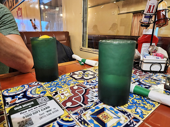 Those vibrant green drinks aren't from some fancy mixologist—they're Stoby's Mexican Punch, the perfect companion to your train car feast.