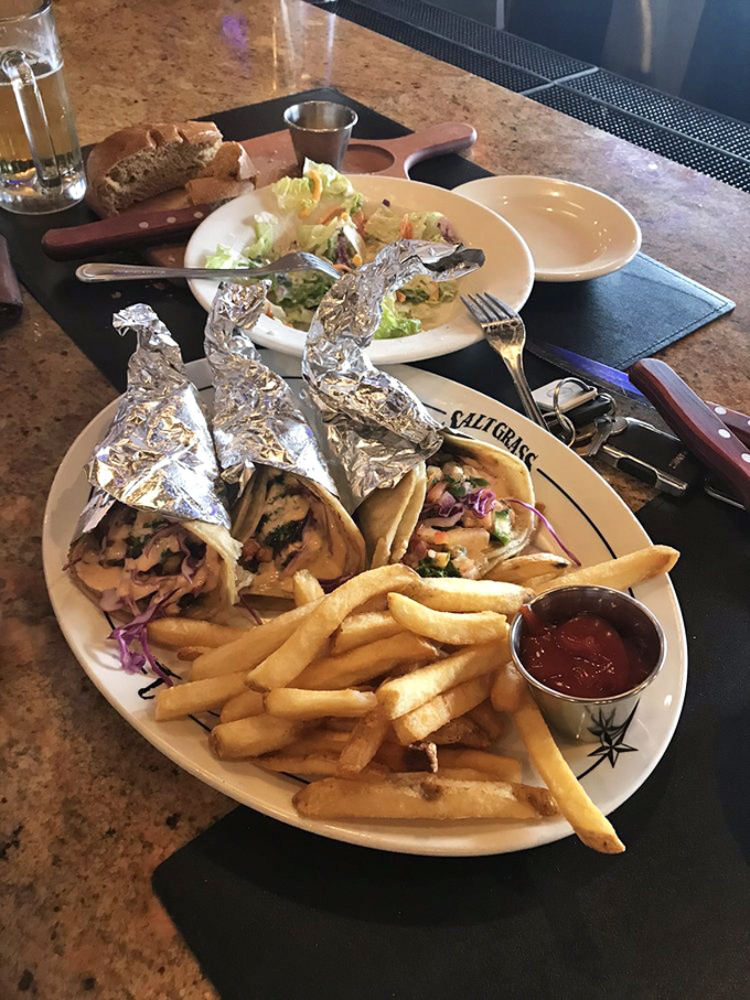 Tacos wrapped in foil like the culinary gifts they are. The fries are just there to make sure you don't float away in happiness.