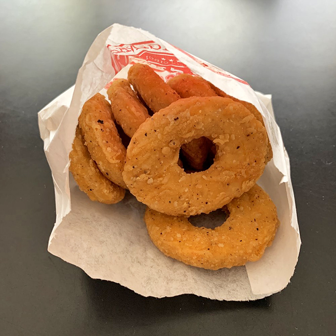These golden-fried onion rings aren't just side dishes; they're crispy halos of happiness that deserve their own moment of silence.