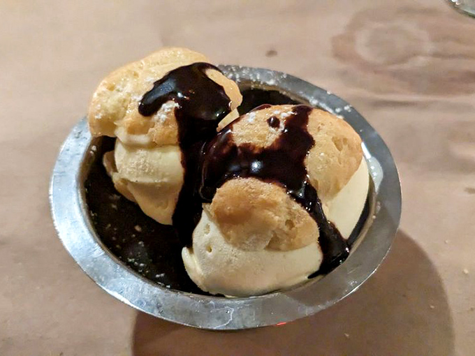 Classic profiteroles with hot chocolate sauce poured tableside&mdash;the sound of your spoon cracking through is better than any symphony.