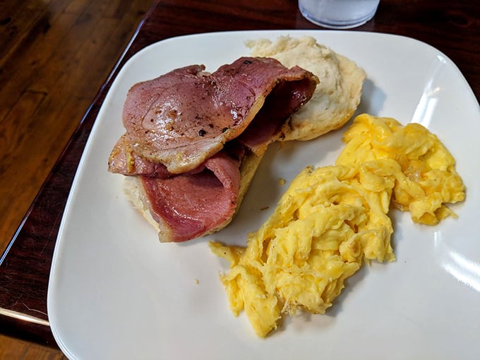 Country ham nestled between a biscuit that could make a Southerner weep with joy, alongside scrambled eggs that practically glow with freshness.