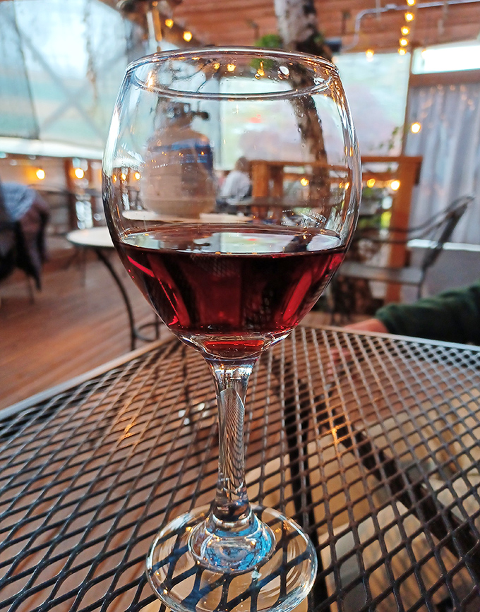 A glass of red wine catching the light just right&mdash;because sometimes Tuesday afternoon deserves a little Parisian-style celebration.