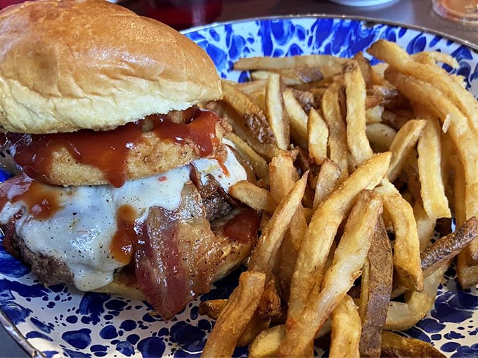 Some burgers merely satisfy hunger; this one, crowned with cheese and nestled beside hand-cut fries, creates lifelong memories.