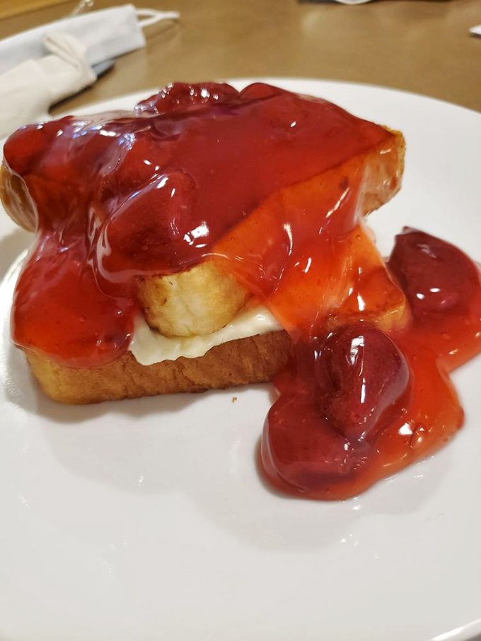 French toast drowning in strawberry topping &ndash; because sometimes breakfast should look like dessert and taste like childhood memories.