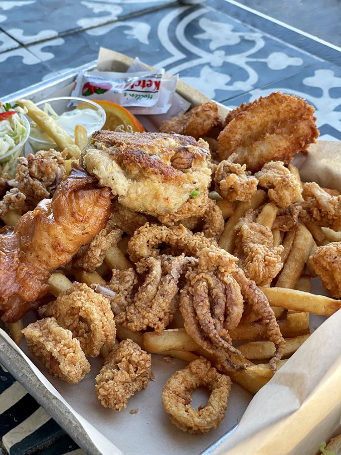 The fried seafood platter that launched a thousand food dreams. Calamari, fish, and fries sharing a tray like old friends at a delicious reunion.