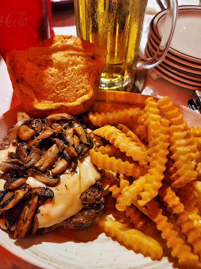Mushrooms and melted cheese transform an ordinary steak into a cowboy's dream, paired with fries that achieved the perfect golden crispness.